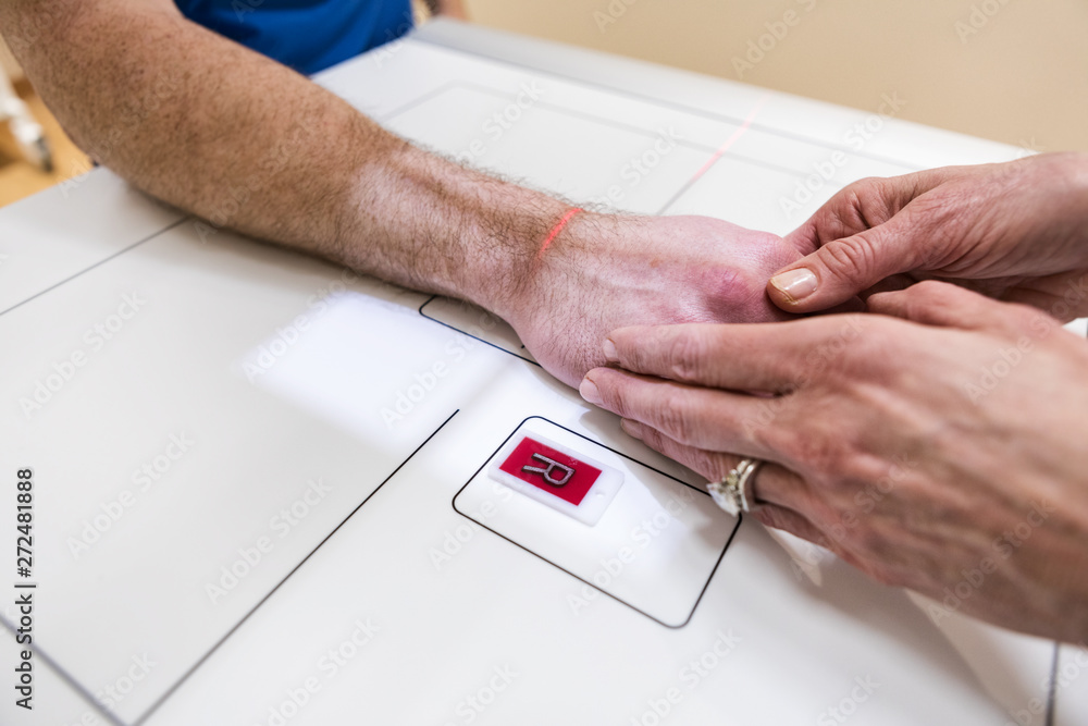 Clinic: Tech Positions Wrist For X-Ray Stock Photo | Adobe Stock