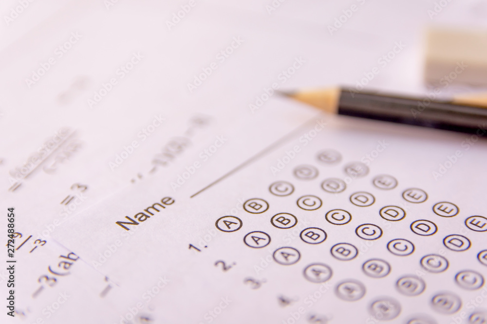 Pencil and eraser on answer sheets or Standardized test form with ...