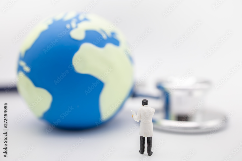 Global Health Care Concept. Close up of doctor miniature figure stanind ...