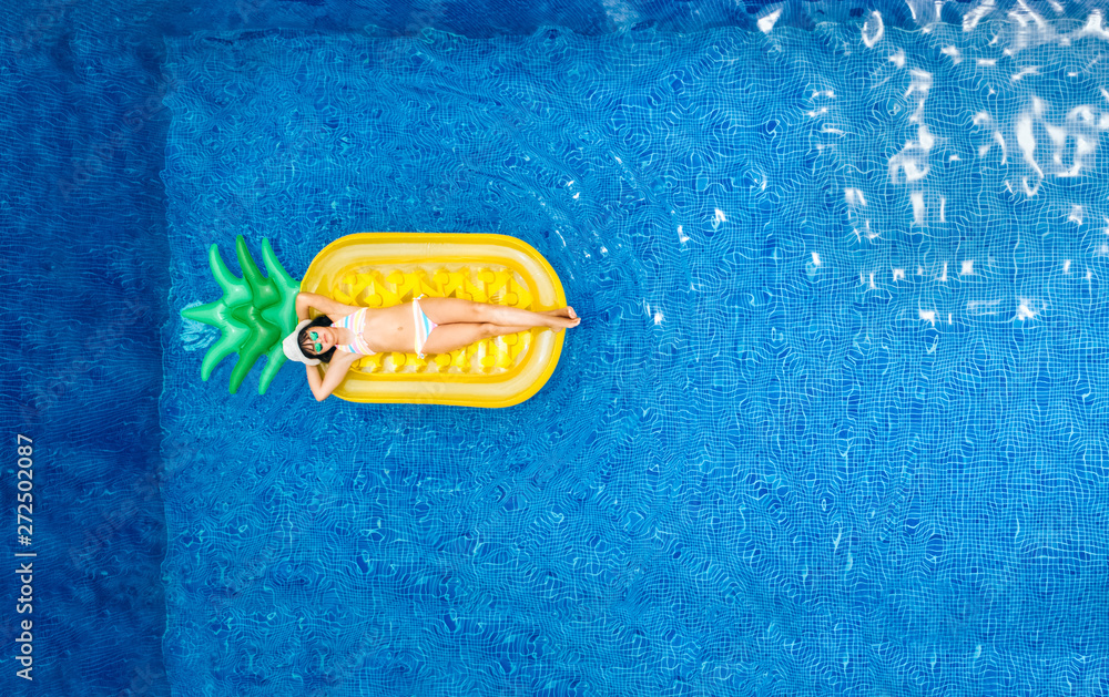 Little girl lying on a pineapple-shaped float in a swimming pool Stock ...