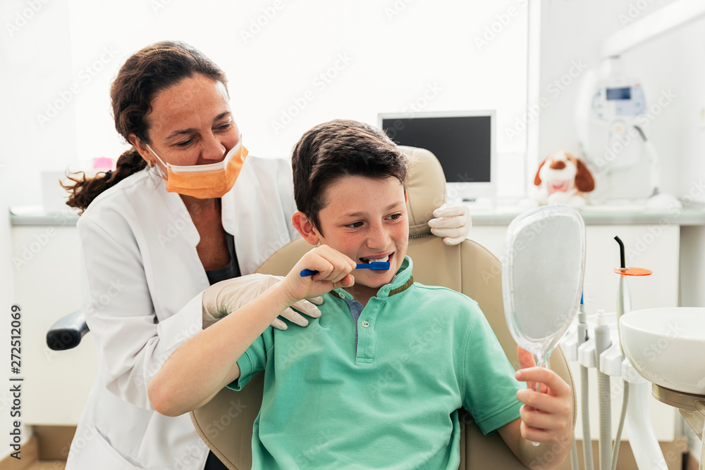Doctor dentist teaching a child to brush teeth. Stock Photo | Adobe Stock