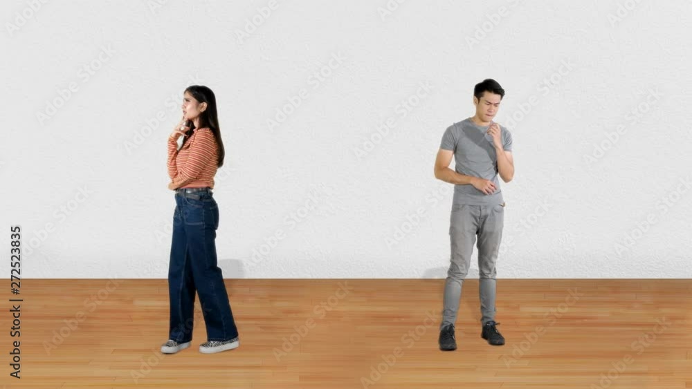 Full length of confused young couple walking back and forth while ...