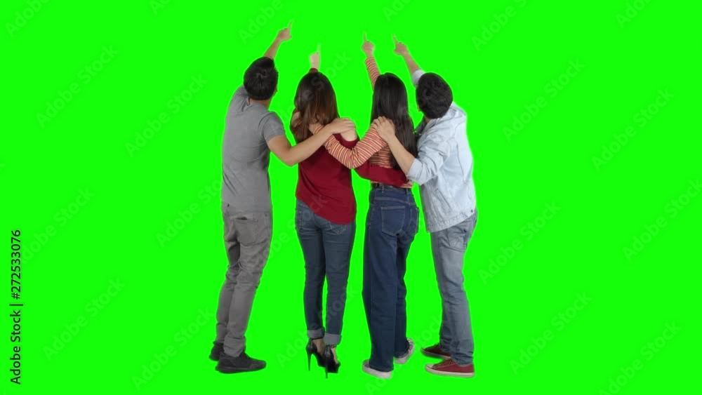 Rear view group of young people pointing and looking up in the studio ...