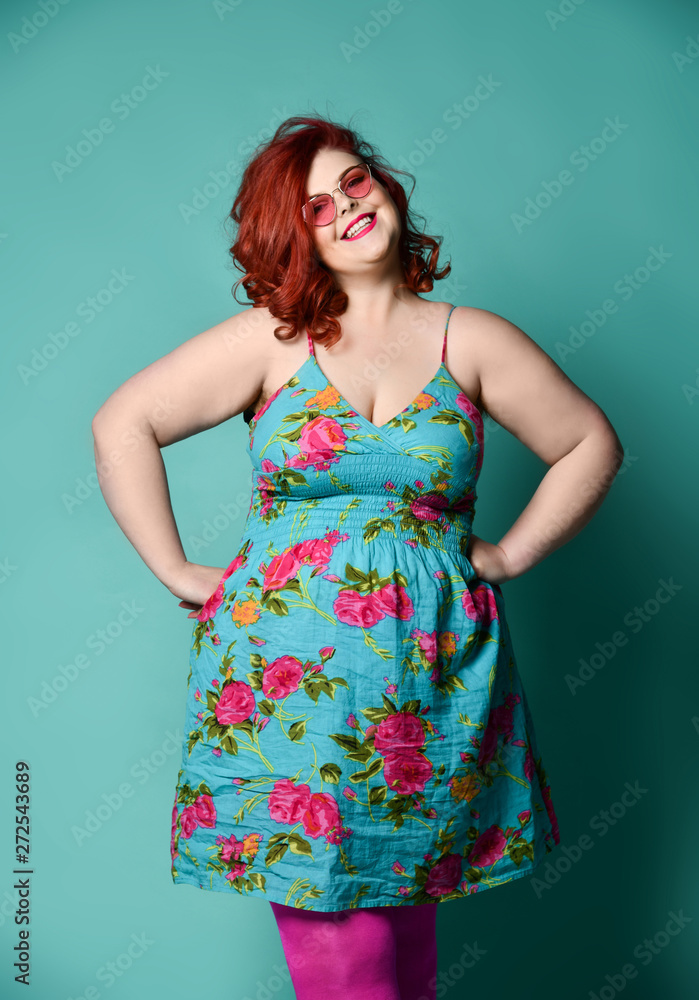 Plus-size fat woman with sincere smile stands with hands on her hips ...