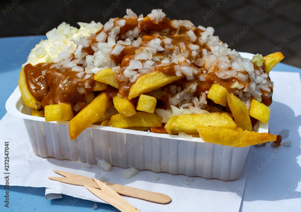 Traditional Dutch fast food dish, fried potatoes with sate sauce, onion ...