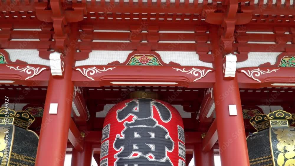 Tilt down from the red wooden roof to the huge lantern at the gate of ...
