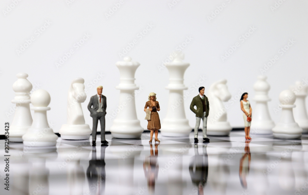 Miniature people standing with chess pieces on the chessboard. Stock 写真 ...