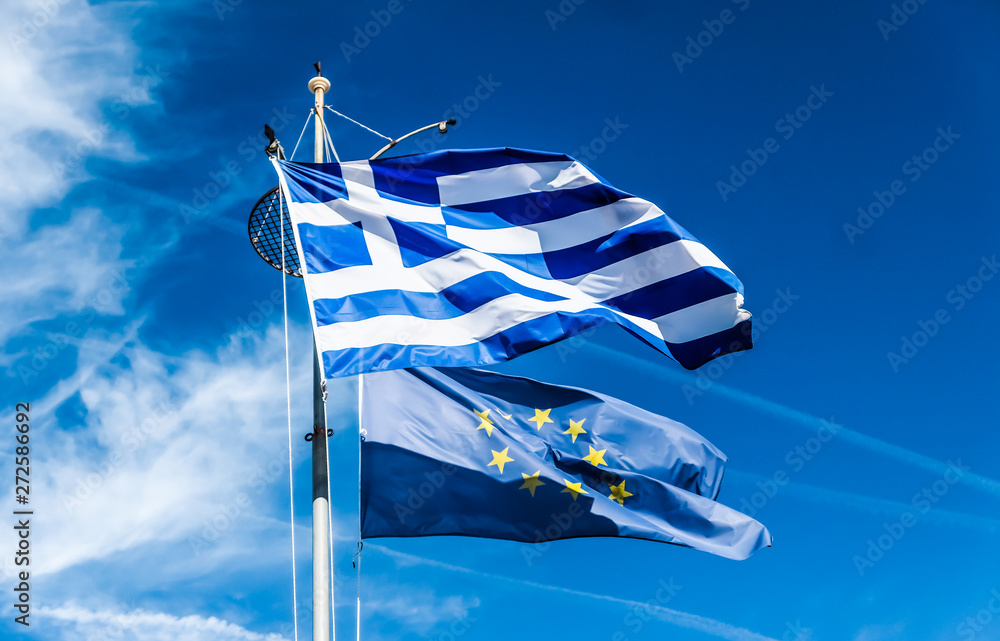 Flags of Greece and European Union on blue sky background, politics of ...