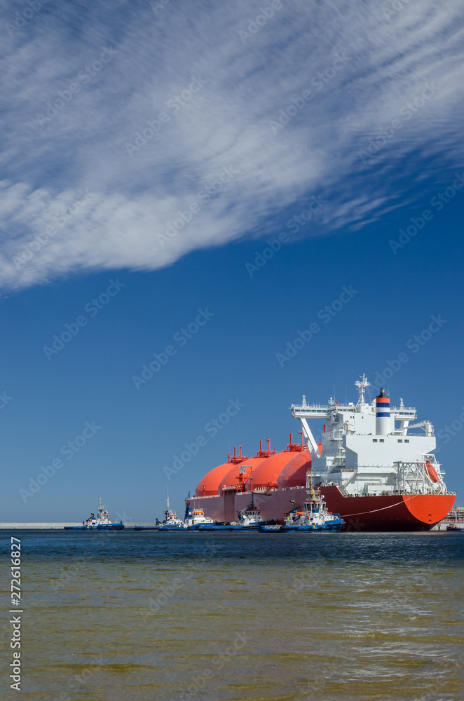 RED LNG TANKER AND A SWARM OF TUGBOATS - A giant ship moored to the gas ...