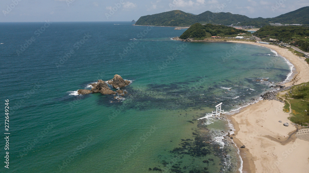 aerial footage of blue ocean, white wave and the twin rocks through the ...