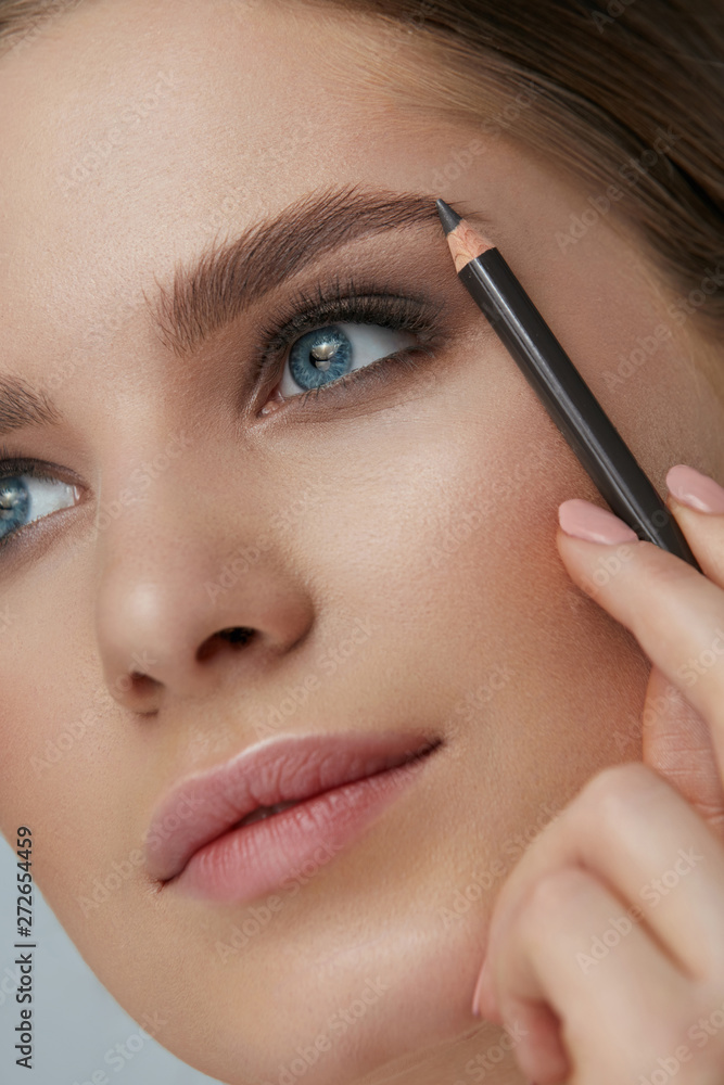Eyebrow makeup. Beauty model shaping brows with brow pencil Stock Photo ...