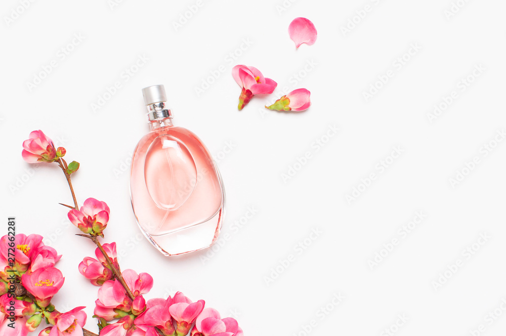 Bottle of women's perfume with pink spring flowers on light gray ...