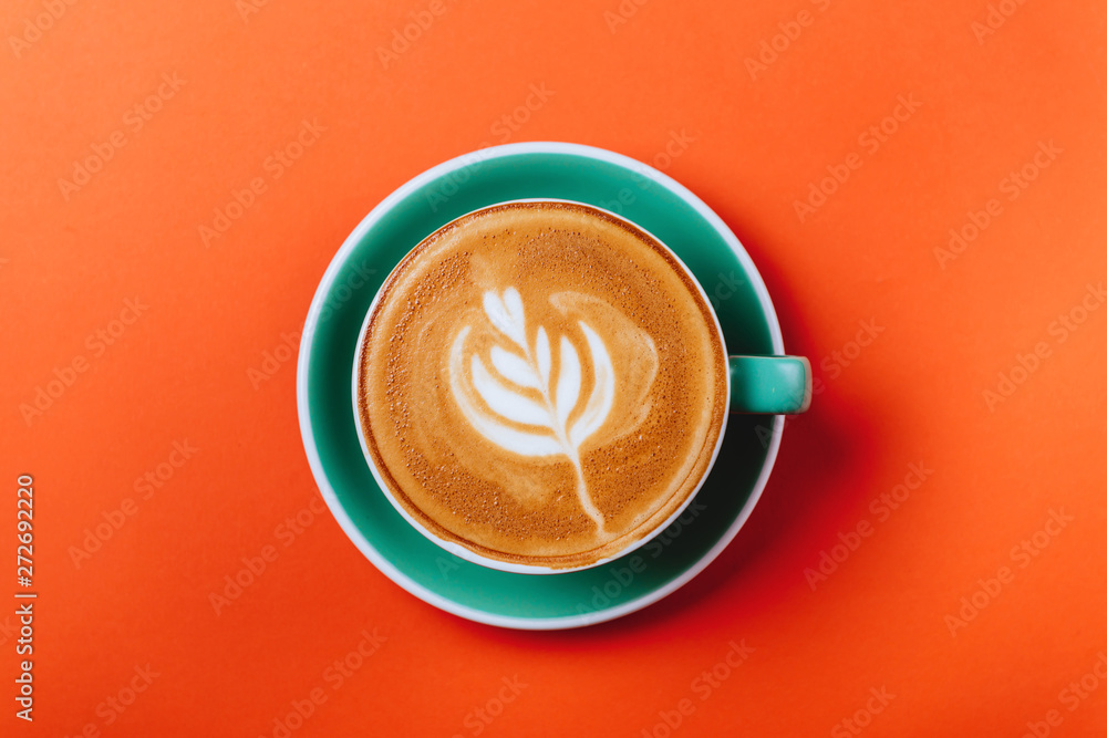 Cyan coffee cup over orange background. Top view flat lay with copy ...