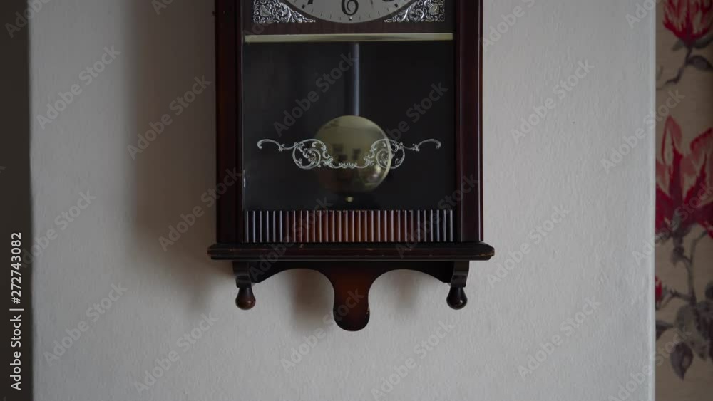 Pendulum swinging on an old pendulum clock. A steady face on shot. Loop ...