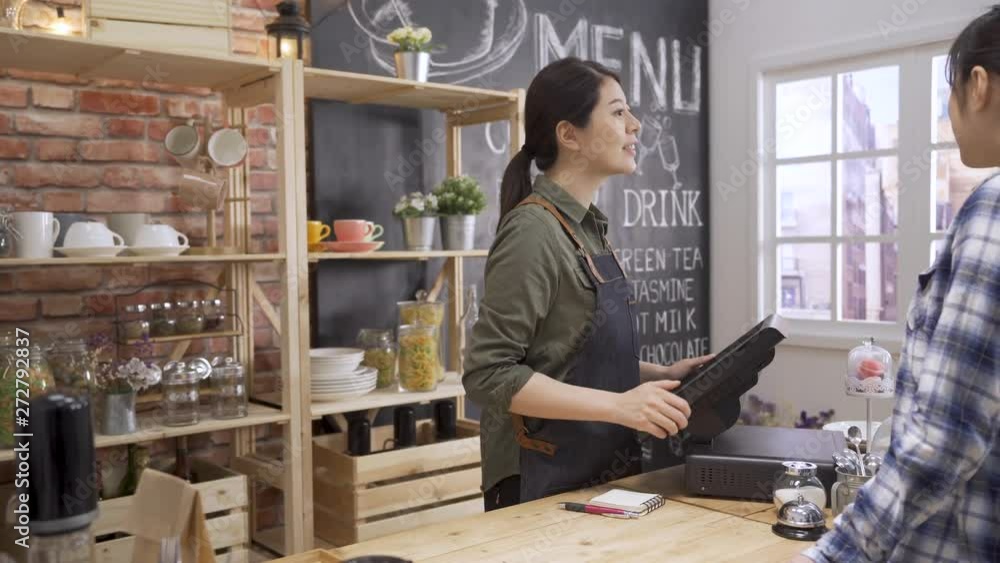 asian female customer ordering at counter in coffee shop. friendly ...