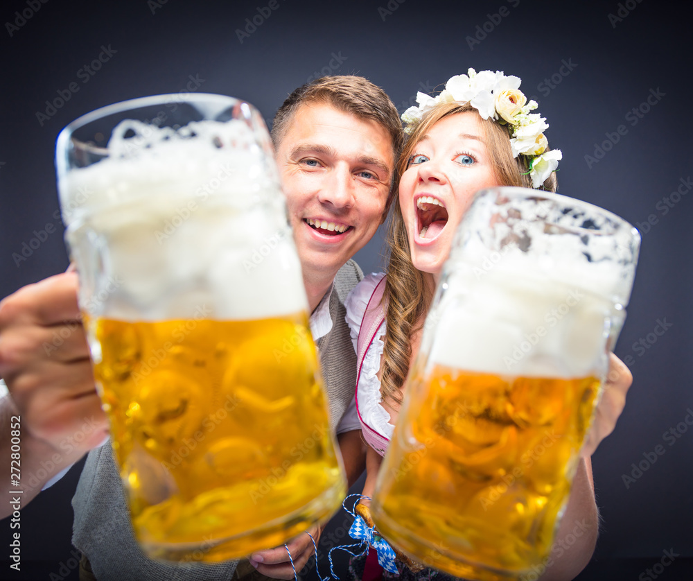 Mann und Frau stoßen mit Maß bier an und lachen auf dem Oktoberfest ...
