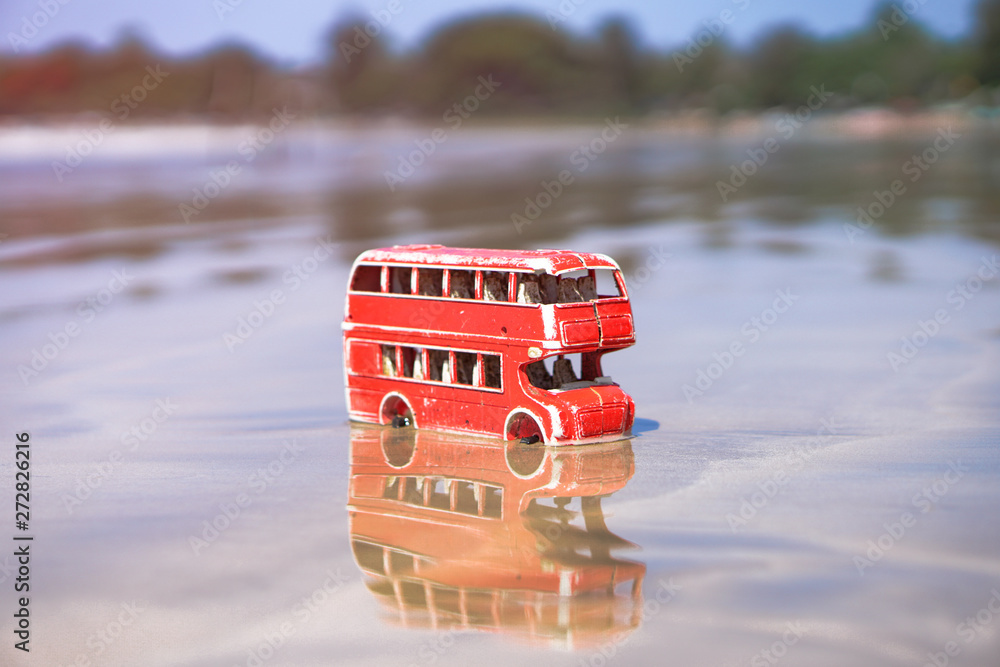 Red toy bus in nature pollutes the earth's ecosystem. English bus ...