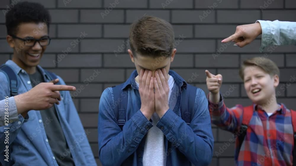 Cruel teenagers pointing at boy crying, emotionally depressed victim of ...