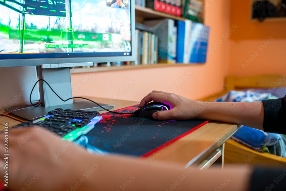 Young teenage boy playing video games on personal computer, focus on ...