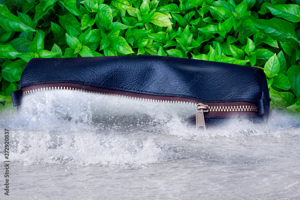 Water flowing out from bag with the green leaves on background : save ...