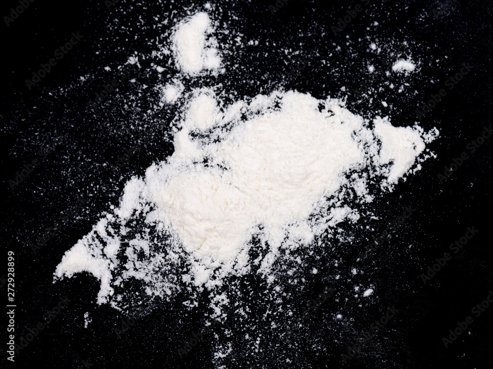 Powder explosion cloud against black background.White dust particles ...