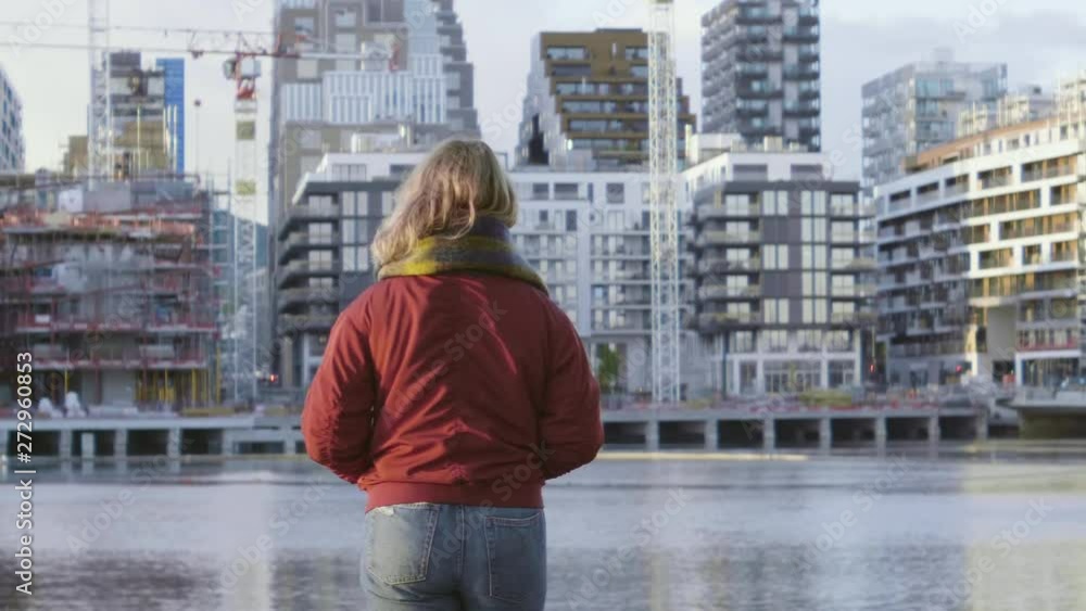 4K video with gimbal pan motion of woman with jeans and a red jacket ...