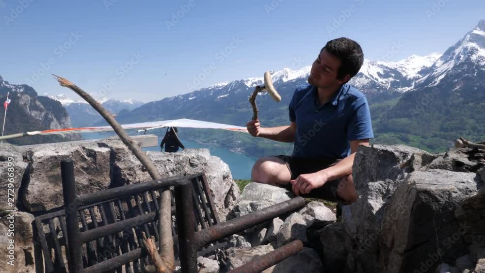 Vidéo Stock Slow motion shot of a young man grilling a sausage over a ...