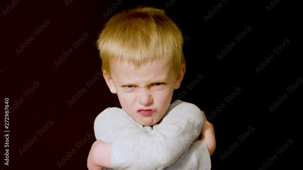 Motion studio portrait of a grumpy little boy upset that he isn't ...