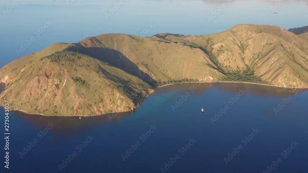 Soft afternoon light illuminates the scenic island of Gili Banta, just ...