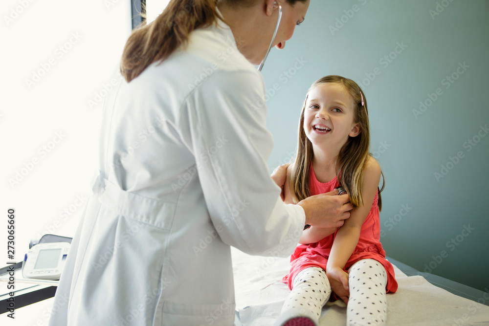 Woman doctor holds stethoscope to young girl's chest Stock Photo ...