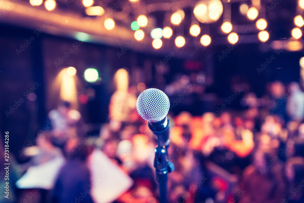 Event hall: Close up of microphone stand, seats with audience in the ...
