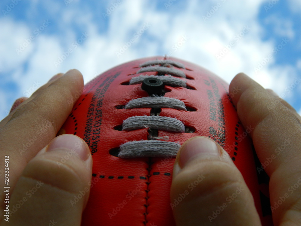 Two hands holding a red football on a sky background Stock Photo ...