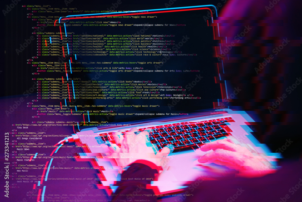 Hacker working with laptop in dark room with digital interface around ...