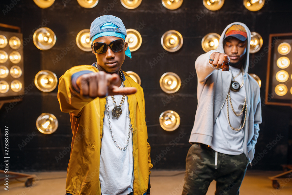 Two black rappers in caps, artists poses on stage Stock Photo | Adobe Stock