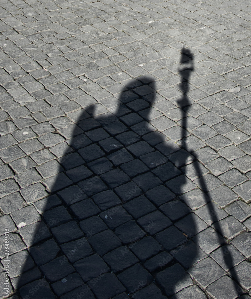 Shadow man, abstract black-and-white image of shadow on cobblestones ...