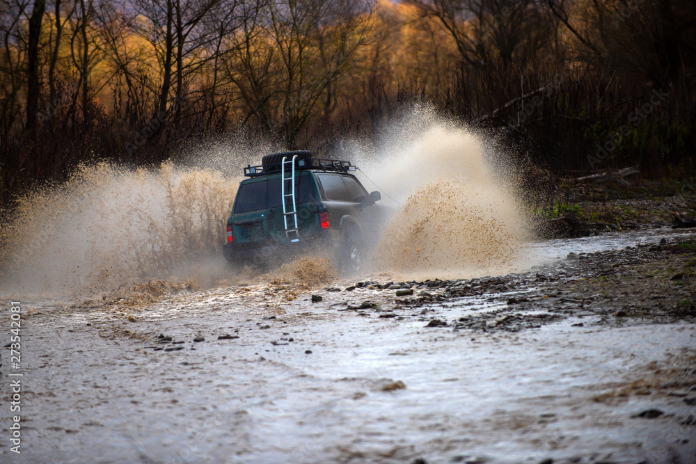 Offroading. Scene of wather splash in off-road racing. A car during a ...