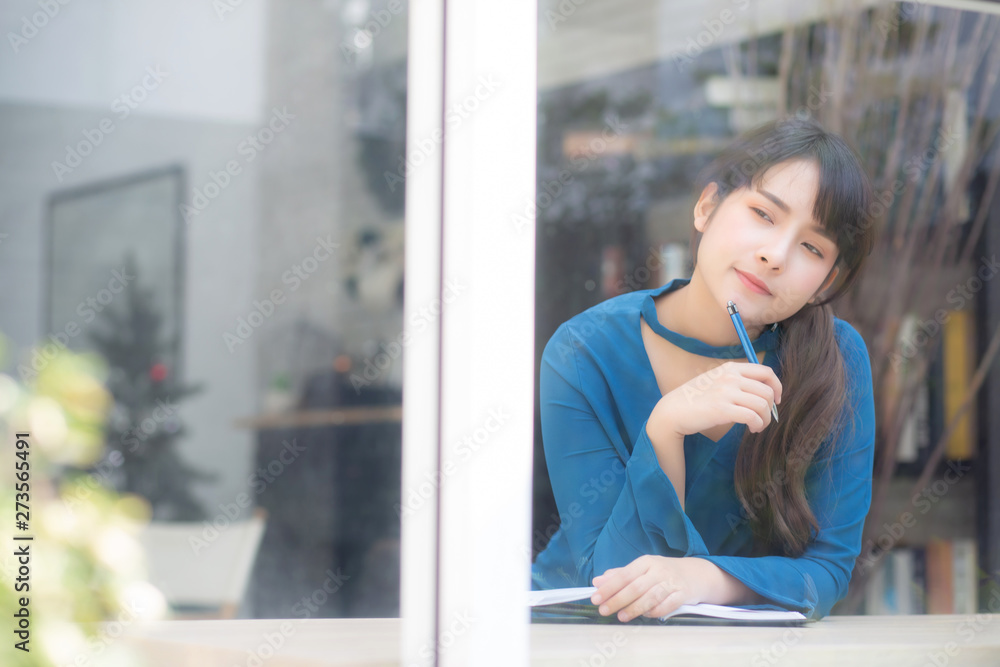Beautiful young asian woman writer smiling thinking idea and writing on ...