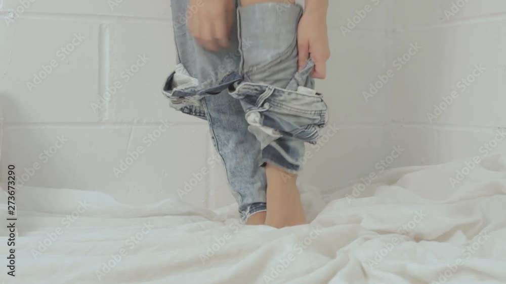 Closeup of woman's legs while taking off denim jeans trousers isolated ...