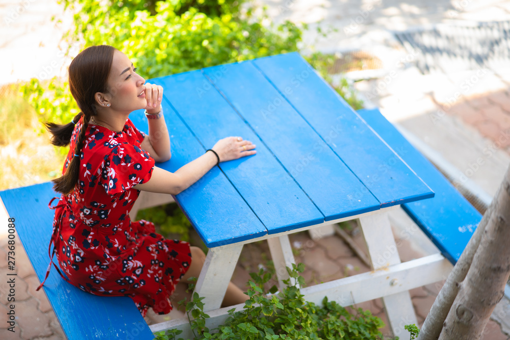 girl in red dress smile relaxing emotional sit table blue color in ...