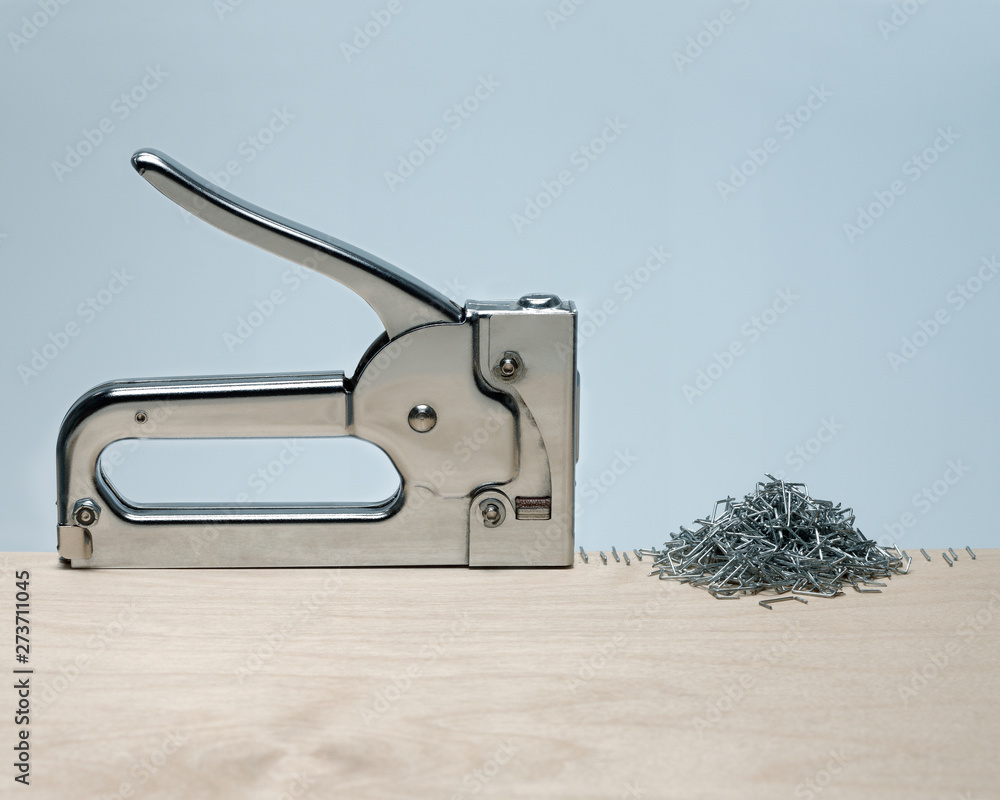 Silver metal stapler malfunctions creating precise row and random pile ...