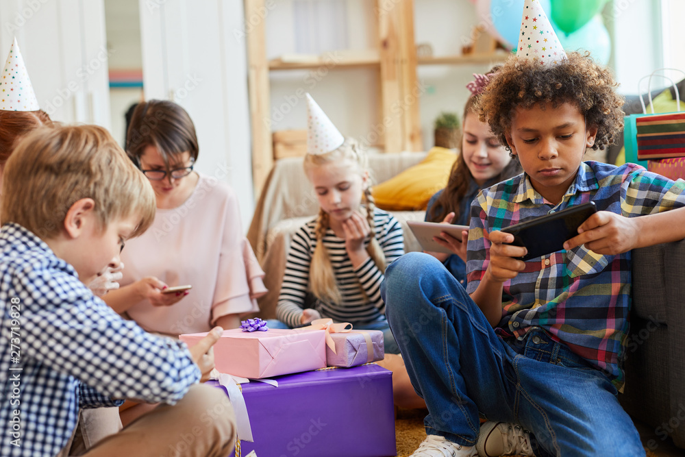 Multi-ethnic group of kids using smartphones at Birthday party, gadget ...