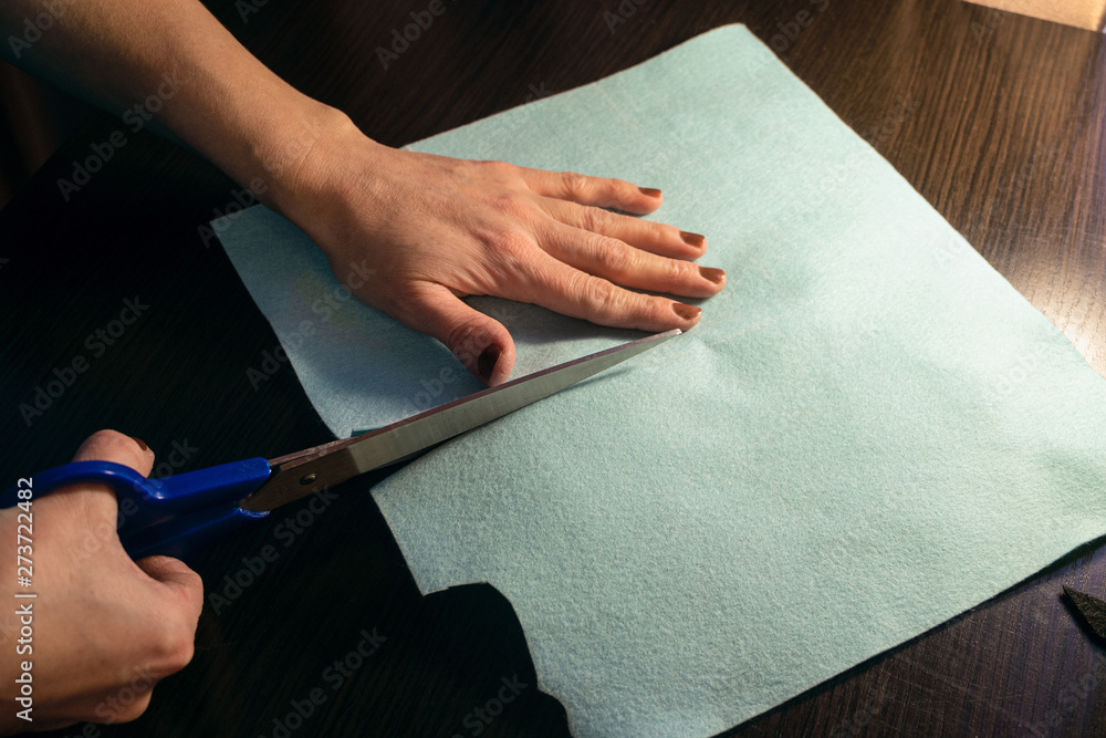 Cutting fabric with scissors. Felt products. Sewing master makes crafts ...