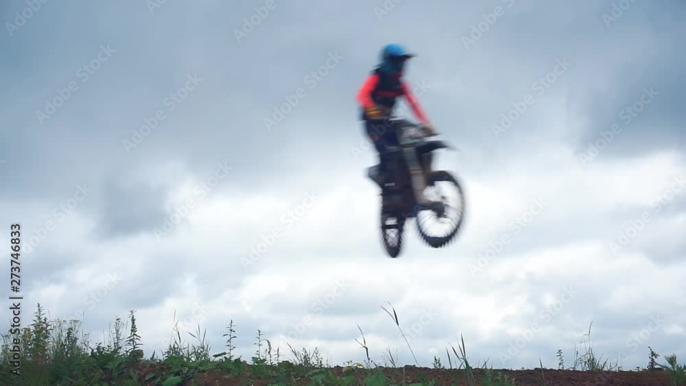 Motocross riders overcome the jump in slow motion. Jumping on a ...