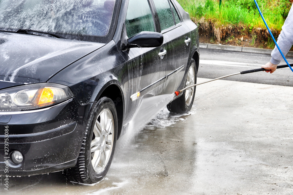 Cleaning Car Using High Pressure Water. Man washing his car under high ...