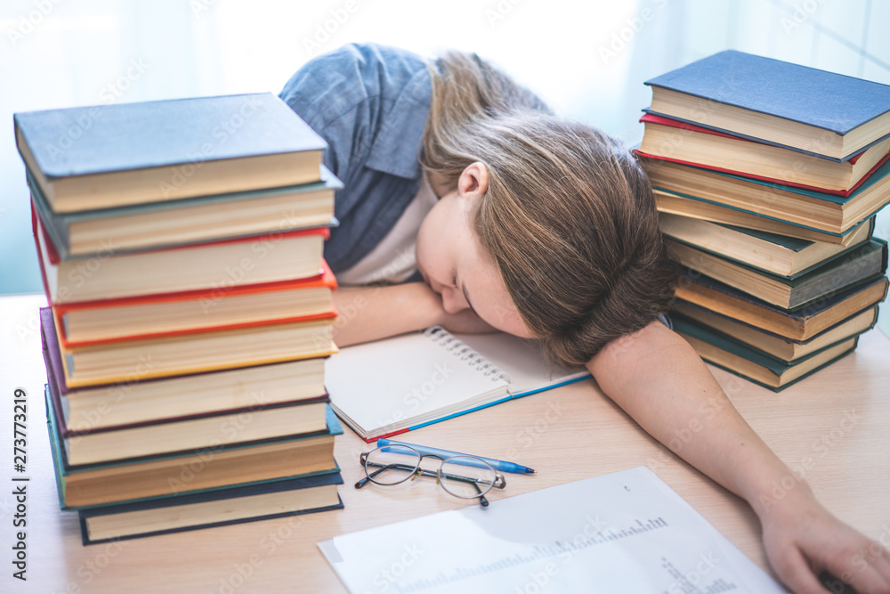 Stressed college student tired of hard learning with books in exams ...