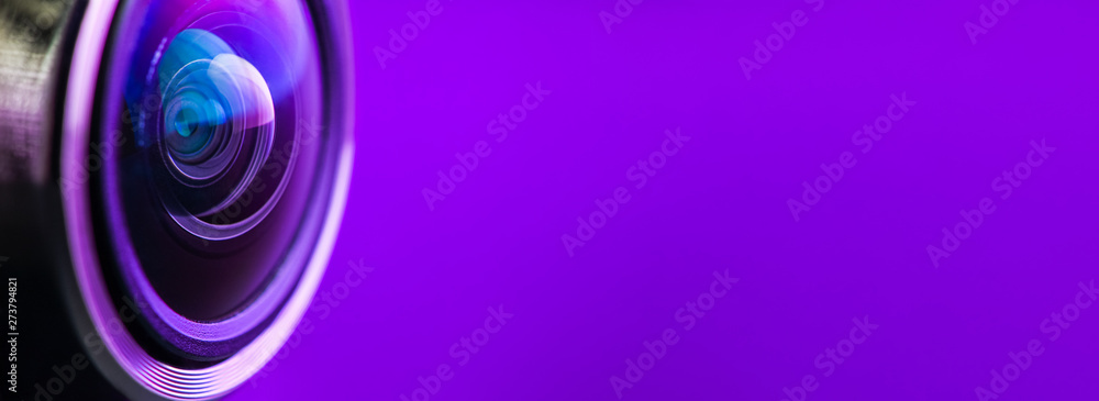 Banner. Camera lens and dark purple backlight. Side view of the lens of ...