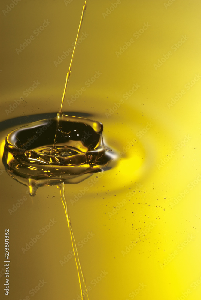 Golden yellow oil dropping and rippling over the abstract background ...