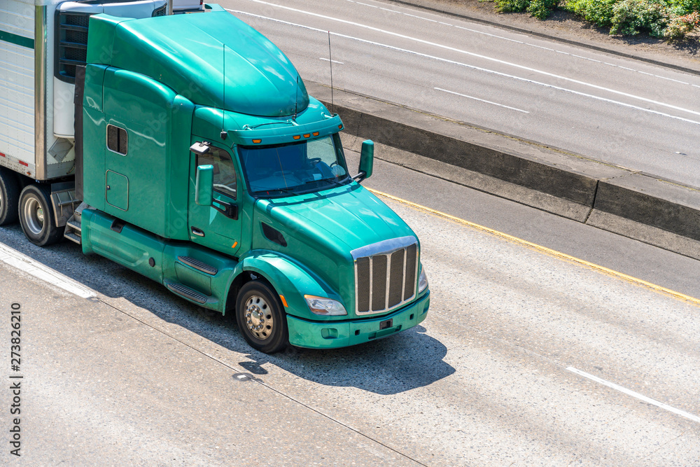Bright green powerful big rig semi truck transporting cargo in ...