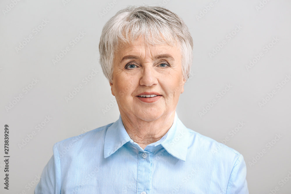 Portrait of elderly woman on light background Stock Photo | Adobe Stock