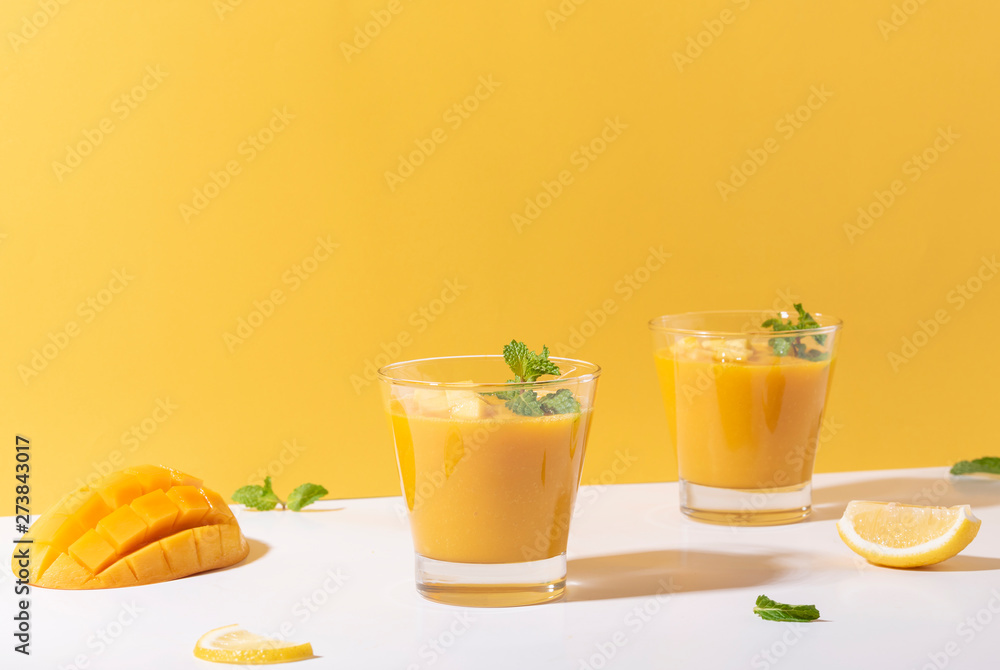 Fresh mango smoothie and ripe mango slice on color background. summer ...